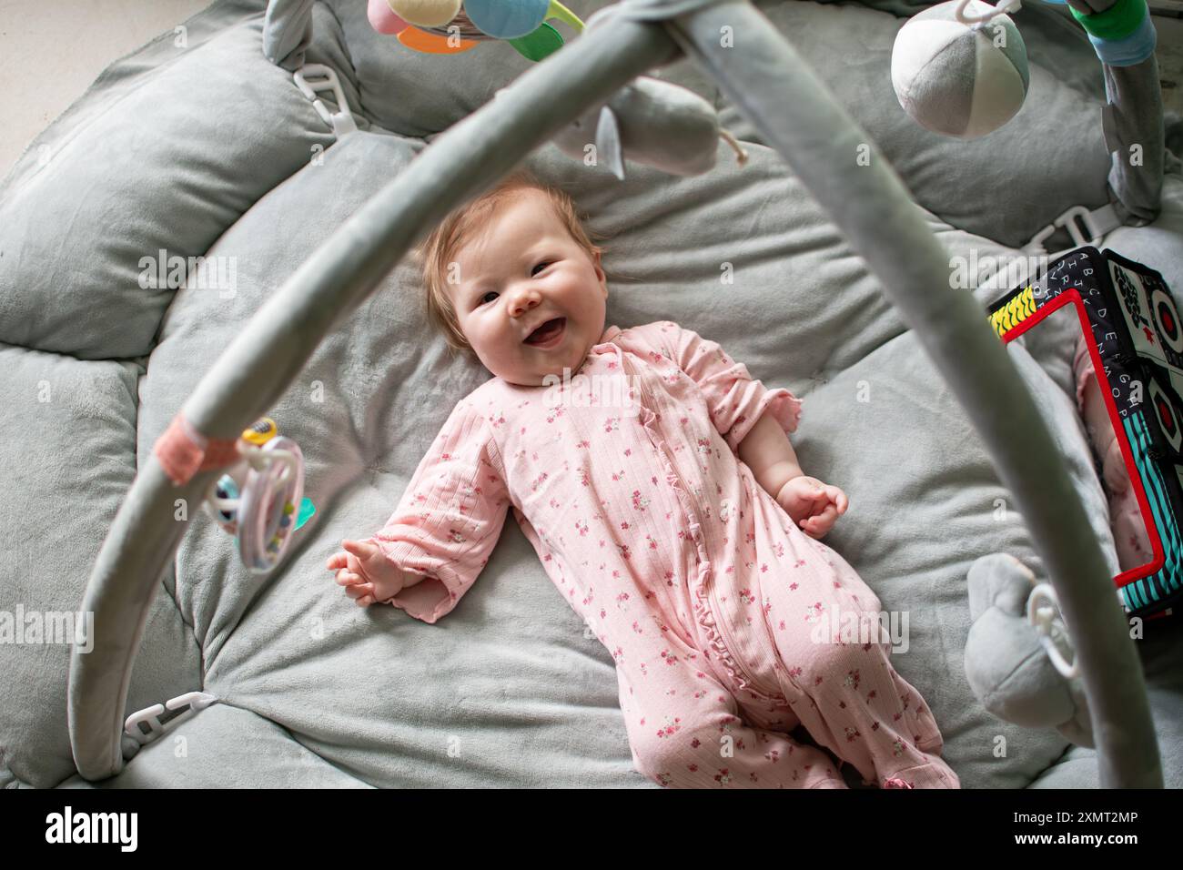 Cute Caucasian newborn baby girl playing on the baby play mat and ...