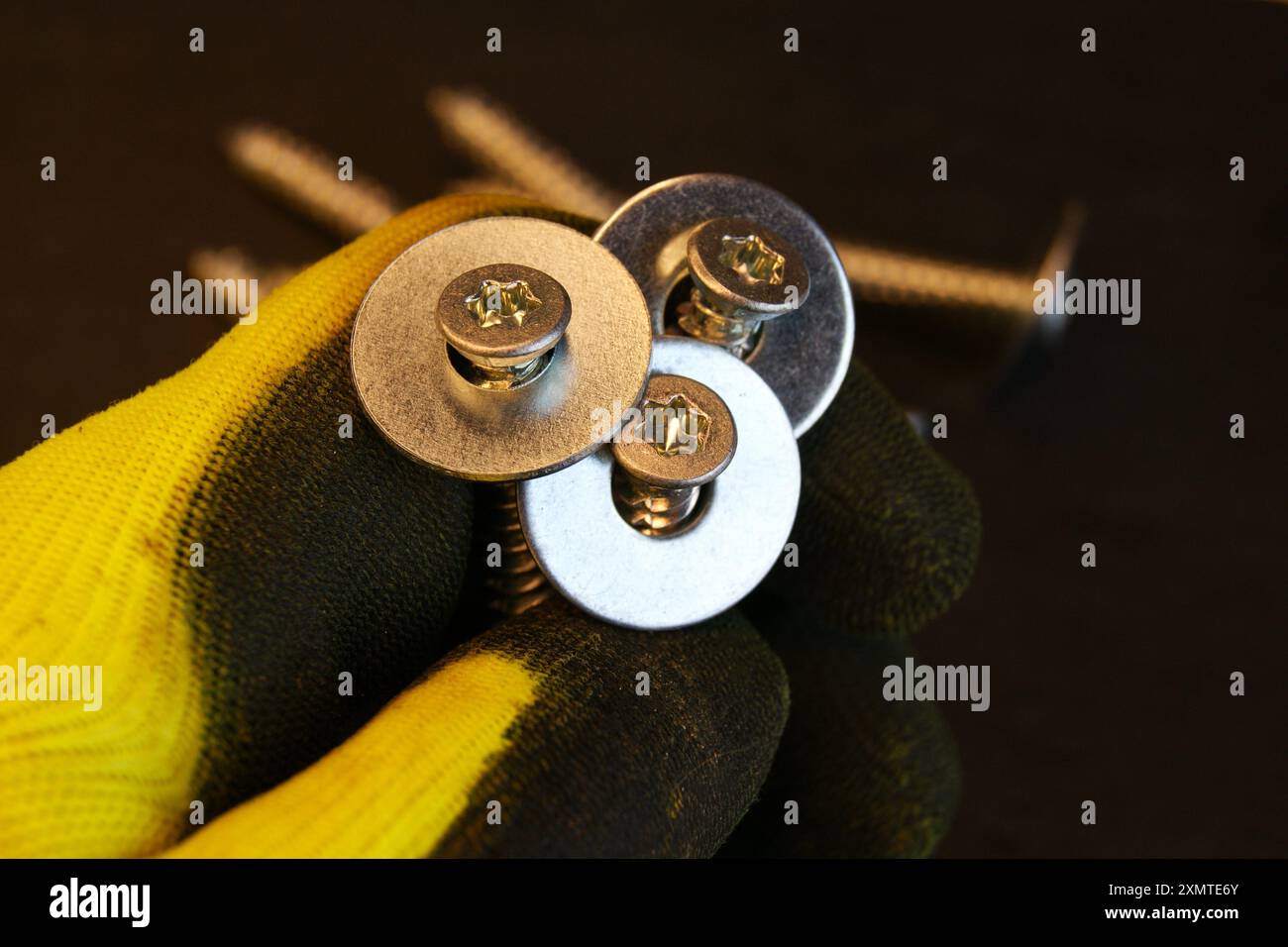 Construction work process. The builder holds large screws Stock Photo ...