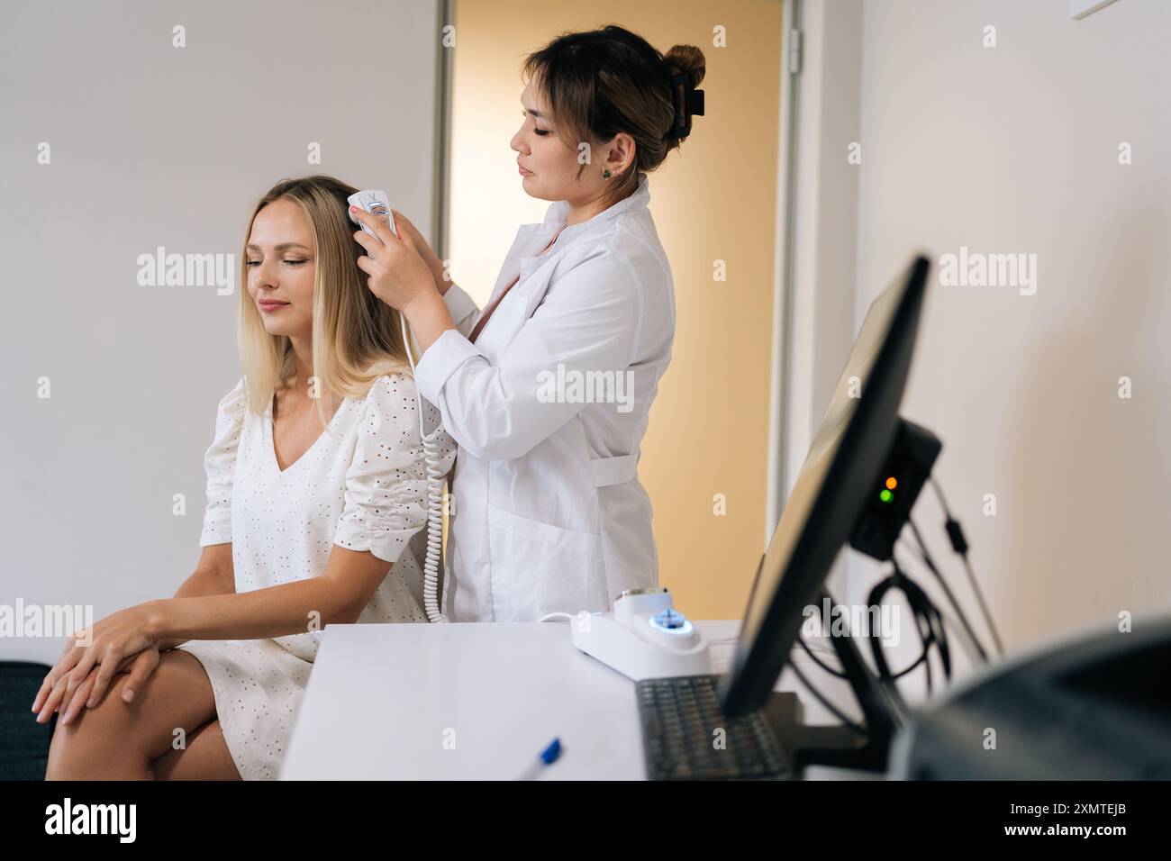Side view of female trichologist making diagnosis of structure and ...