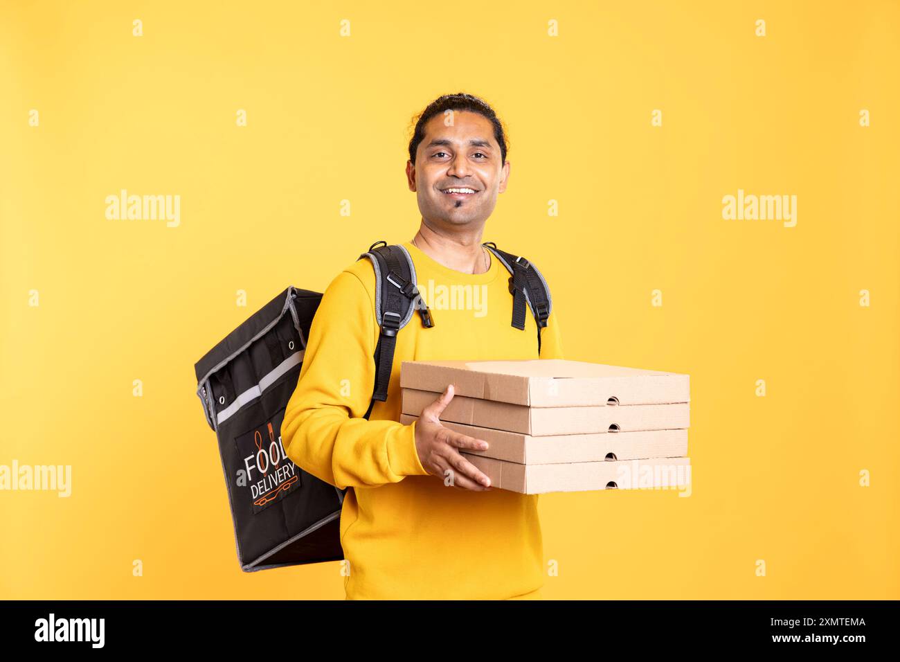 Portrait of smiling pizza delivery worker carrying takeaway orders ...