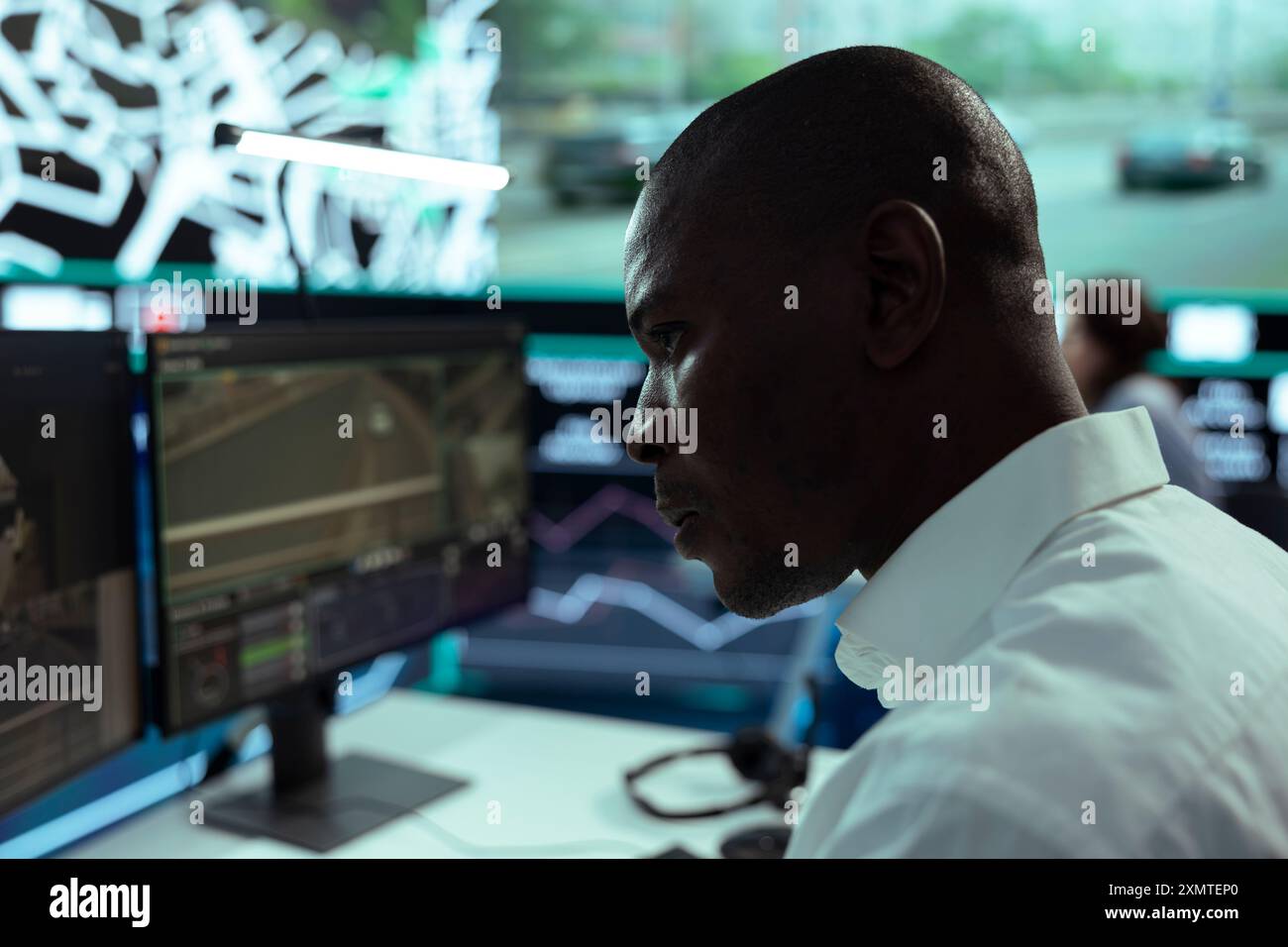 African american employee monitoring traffic and locating truck driver ...