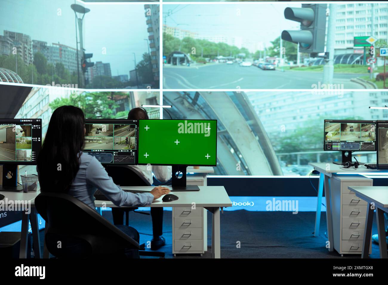 Indian woman working with CCTV footage and greenscreen on computers ...