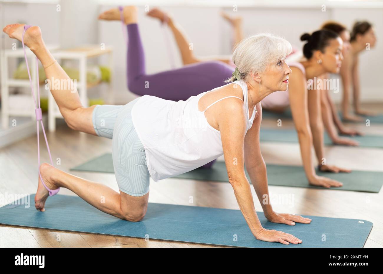 Elderly woman exercising with pilates loop Stock Photo - Alamy
