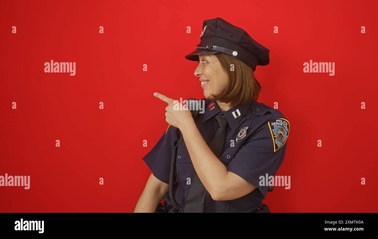 A smiling female police officer points to something off-camera against ...