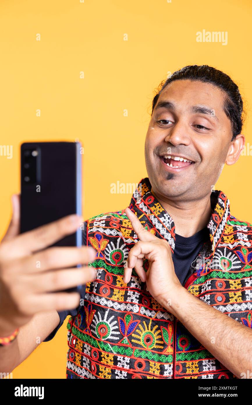 Joyous indian narcissistic man using cellphone to take selfies from all ...