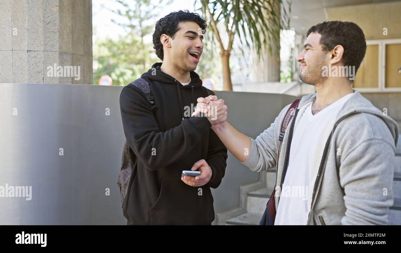 Two men happily greeting each other with a handshake in an urban street ...