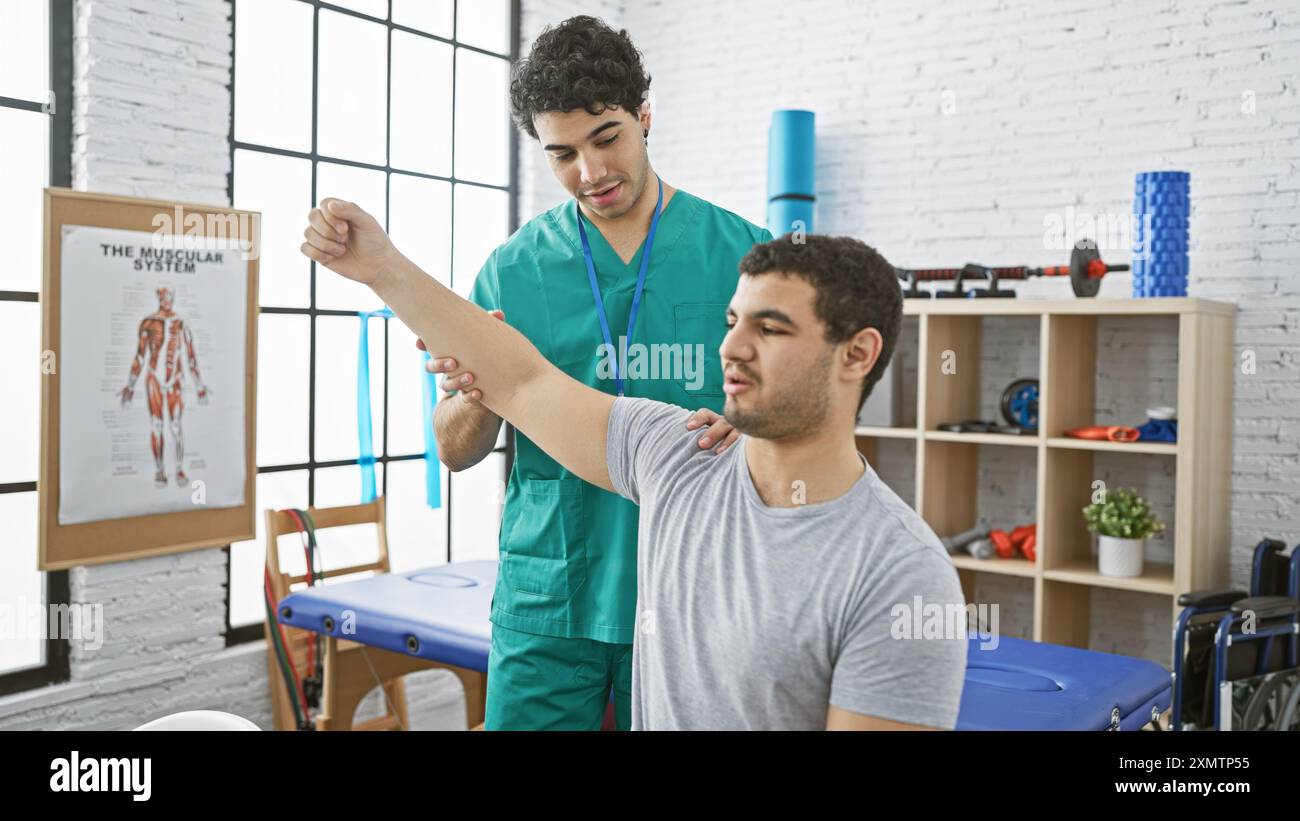 A male physiotherapist is stretching the arm of a male patient in a ...