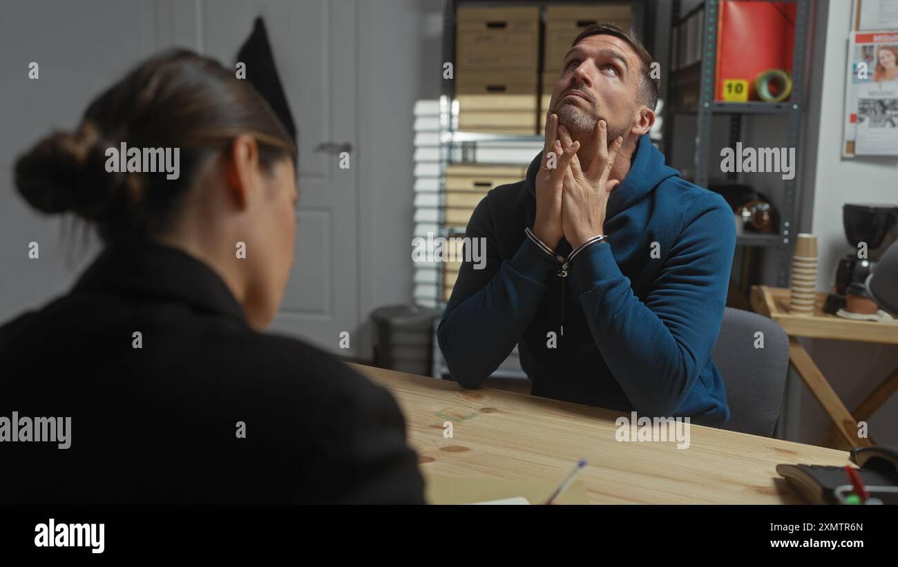 A worried man being questioned by a policewoman in an office ...