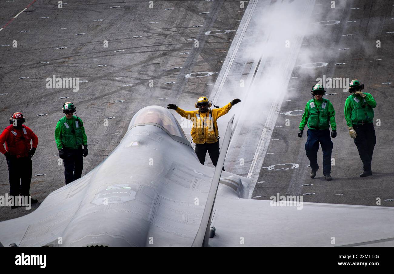 A Sailor directs an F-35C Lightning II from the "Rough Raiders" of ...