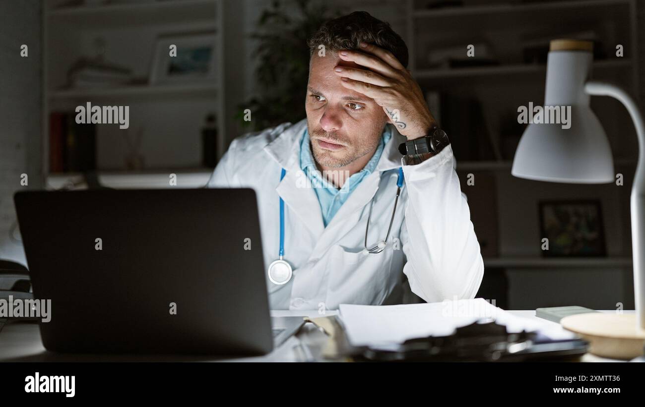 Tired hispanic male doctor in lab coat working late in the hospital ...