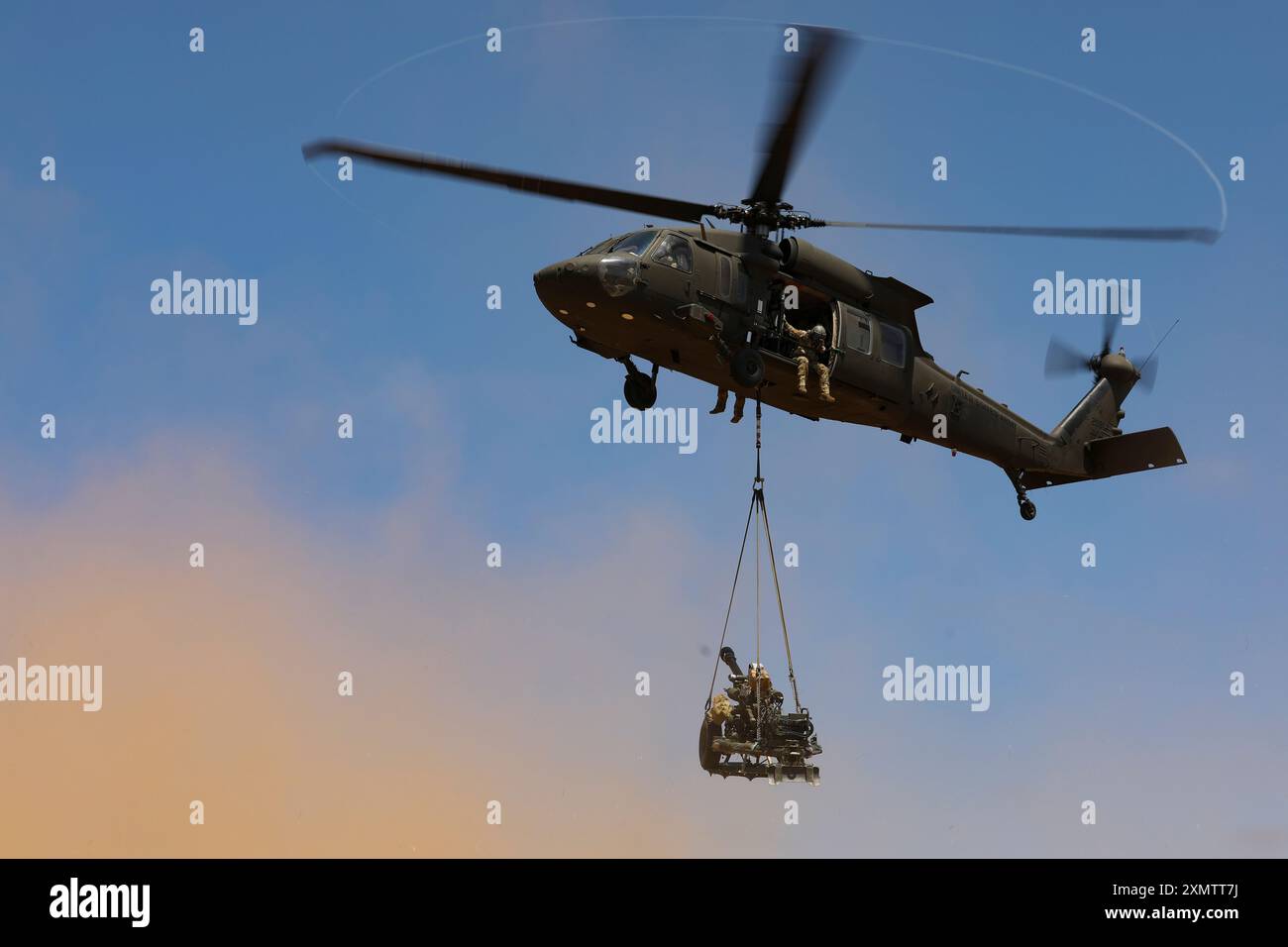 A Sikorsky UH-60 Black Hawk lifts a M1193A Howitzer into the air during ...