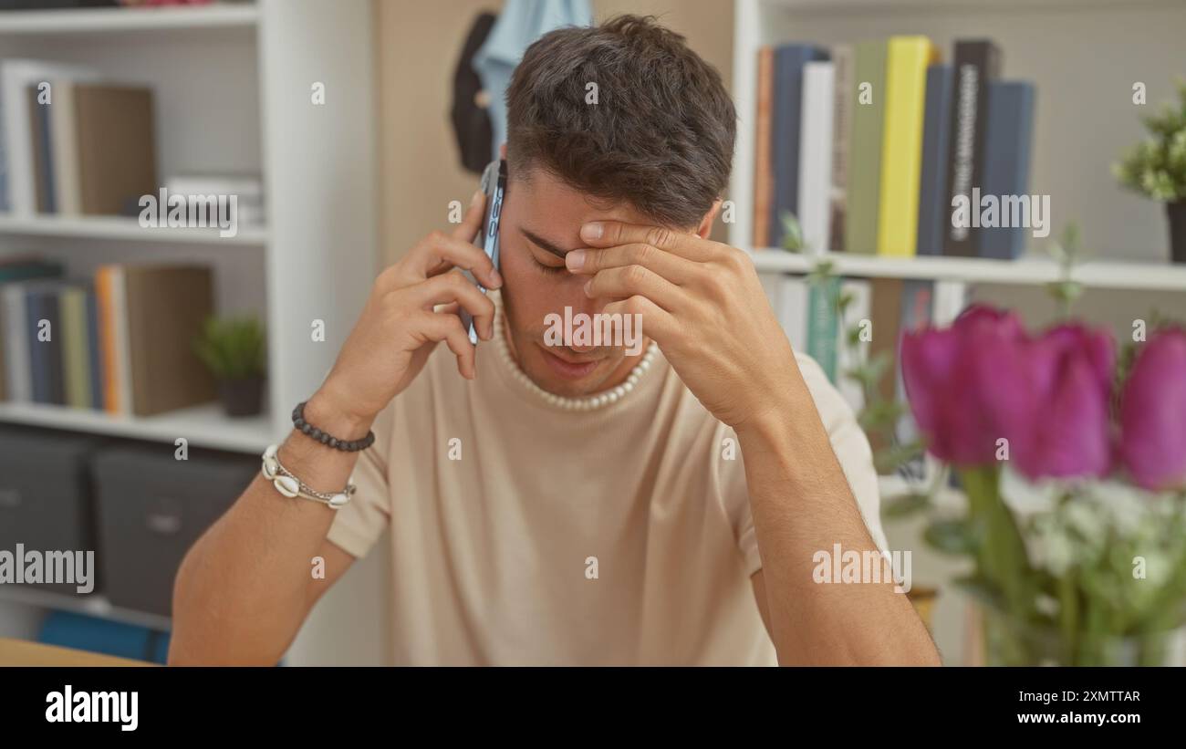 Stressed young hispanic man talking on the phone at home with a ...