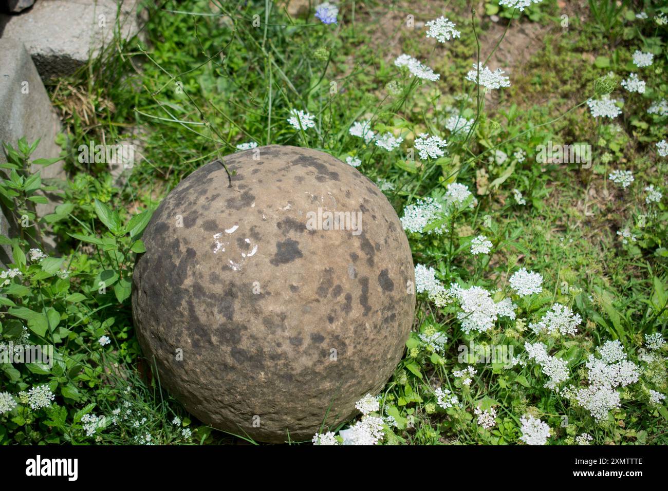 Round stone ball over green grassy background Stock Photo - Alamy
