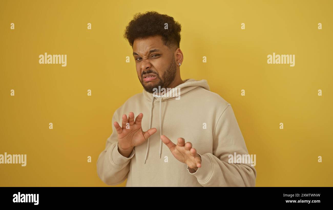 Handsome black man making a disgusted expression against a yellow ...