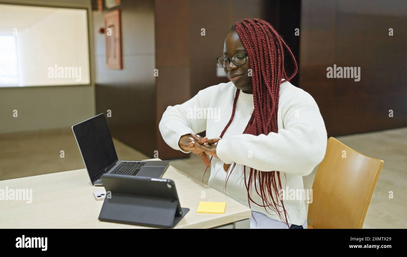 African woman with braids working in an indoor office setting Stock ...