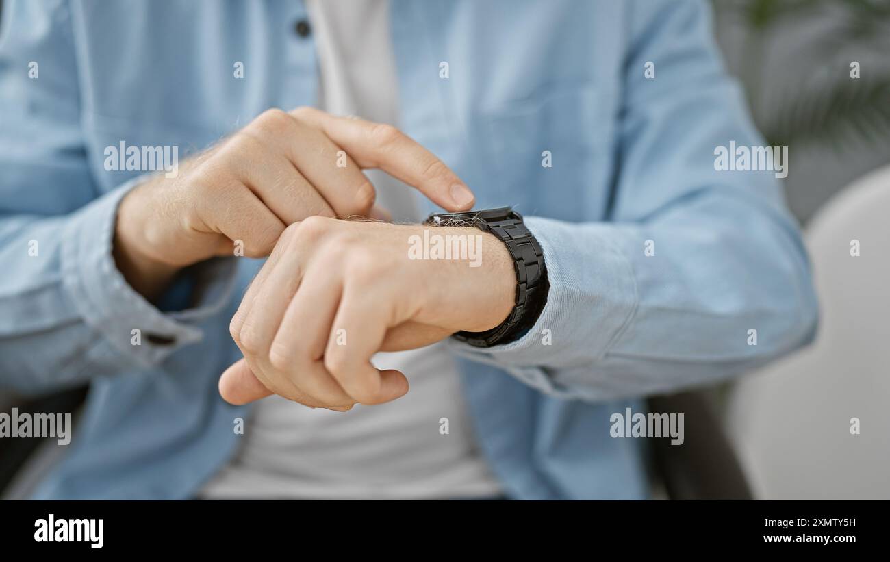 A professional man checks the time on his wristwatch in an office ...