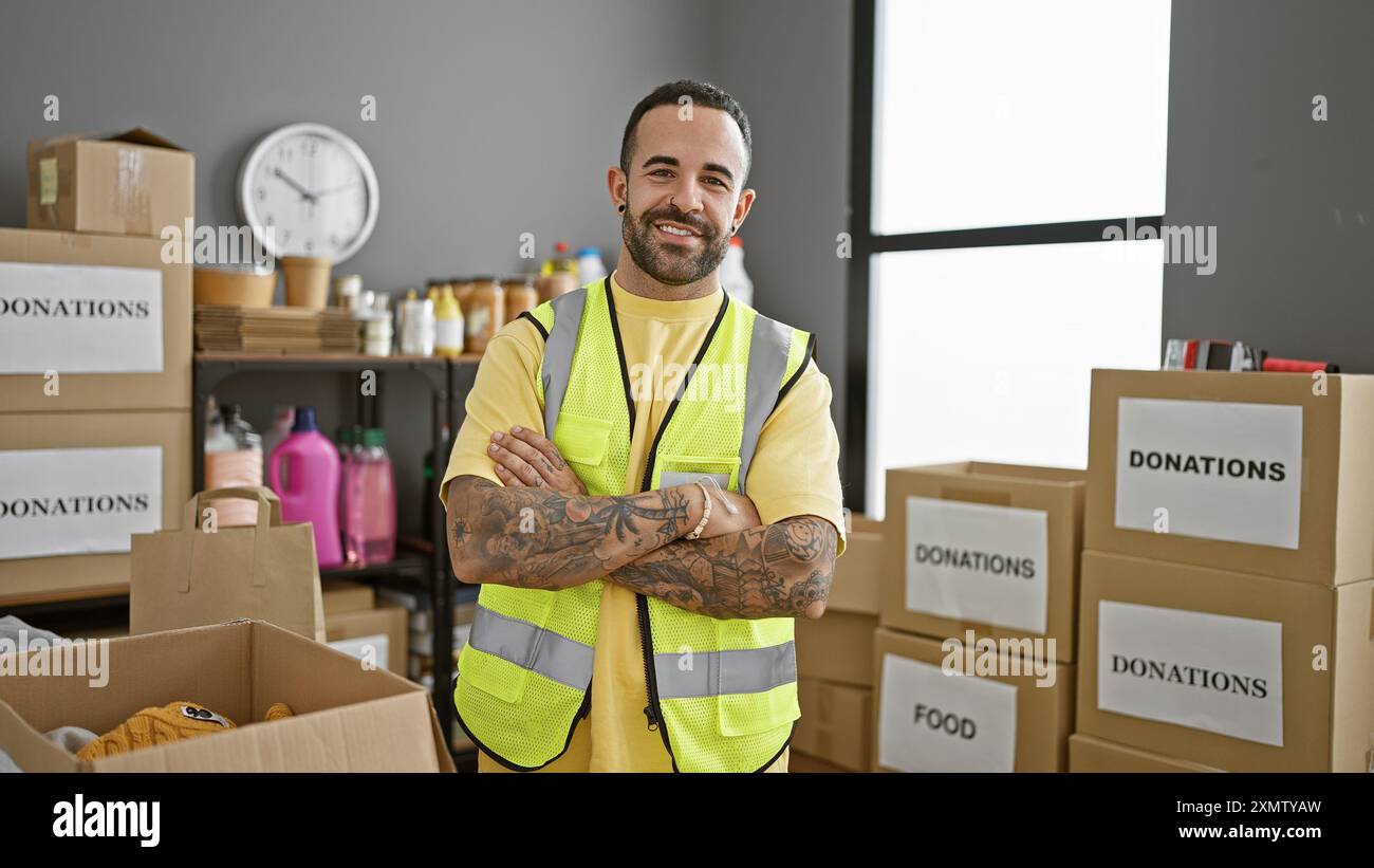 Confident hispanic man in hi-vis vest stands among donation boxes in a ...