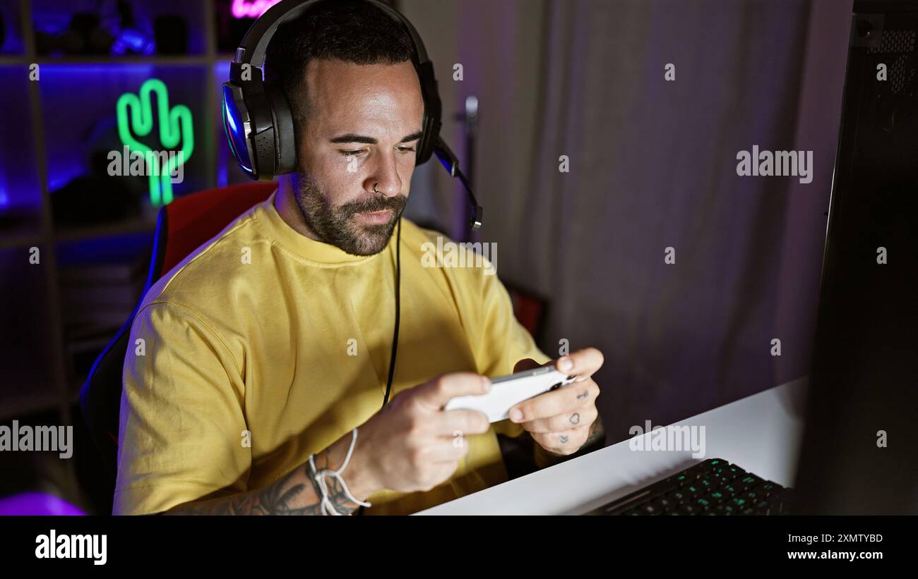 A focused man playing video games in an ambient lit gaming room at ...