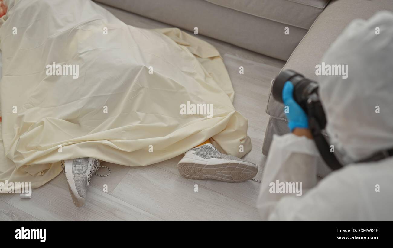 A detective in protective gear photographs evidence at an indoor crime ...