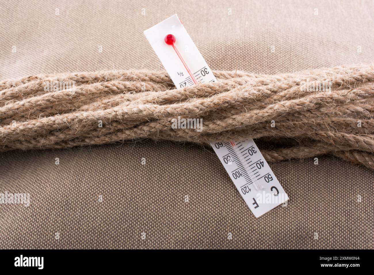 Thermometer placed on a brown rope on a fabric background Stock Photo ...