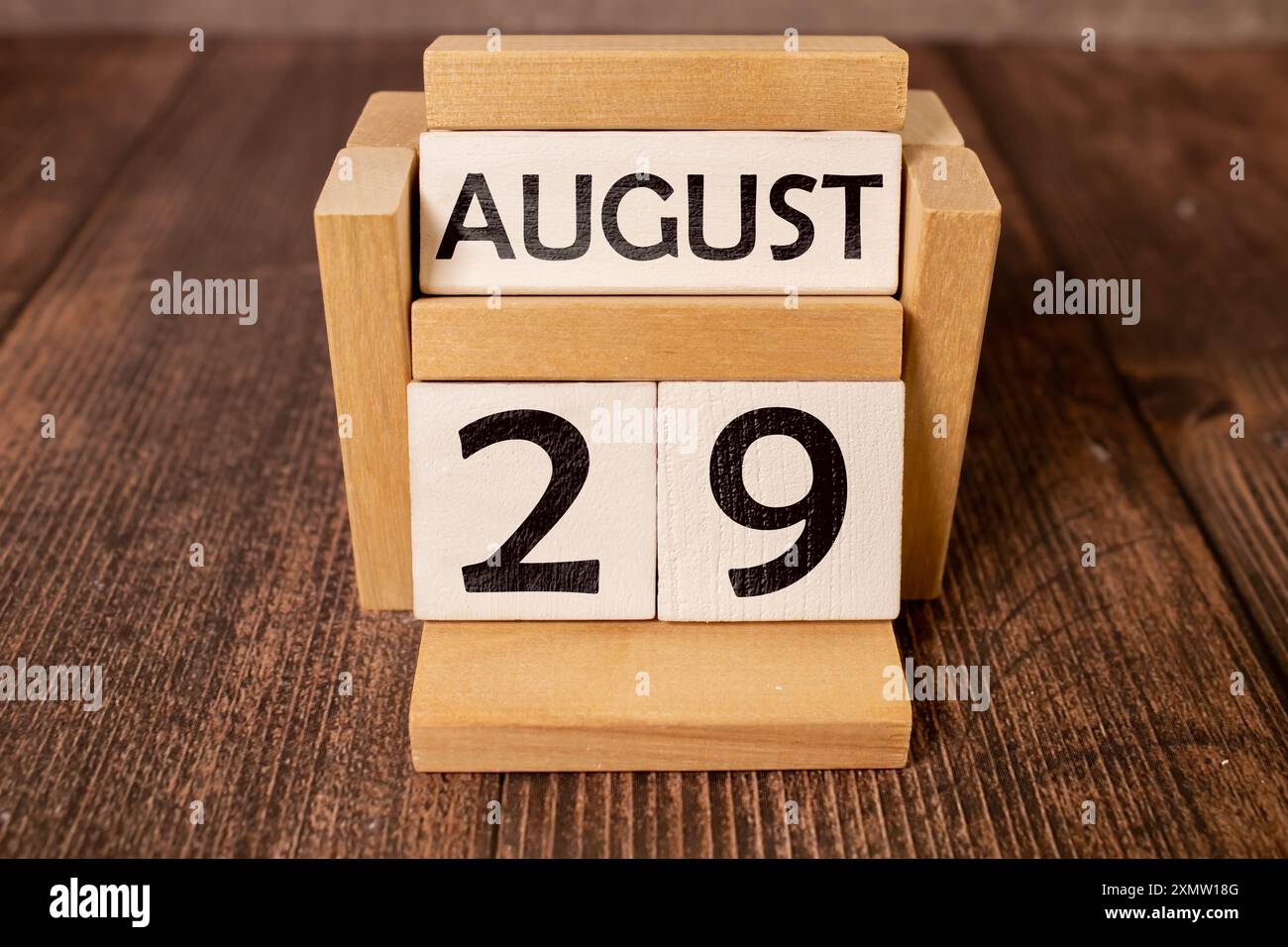 Wooden block calendar with the date August 29 and spikelets of wheat on ...