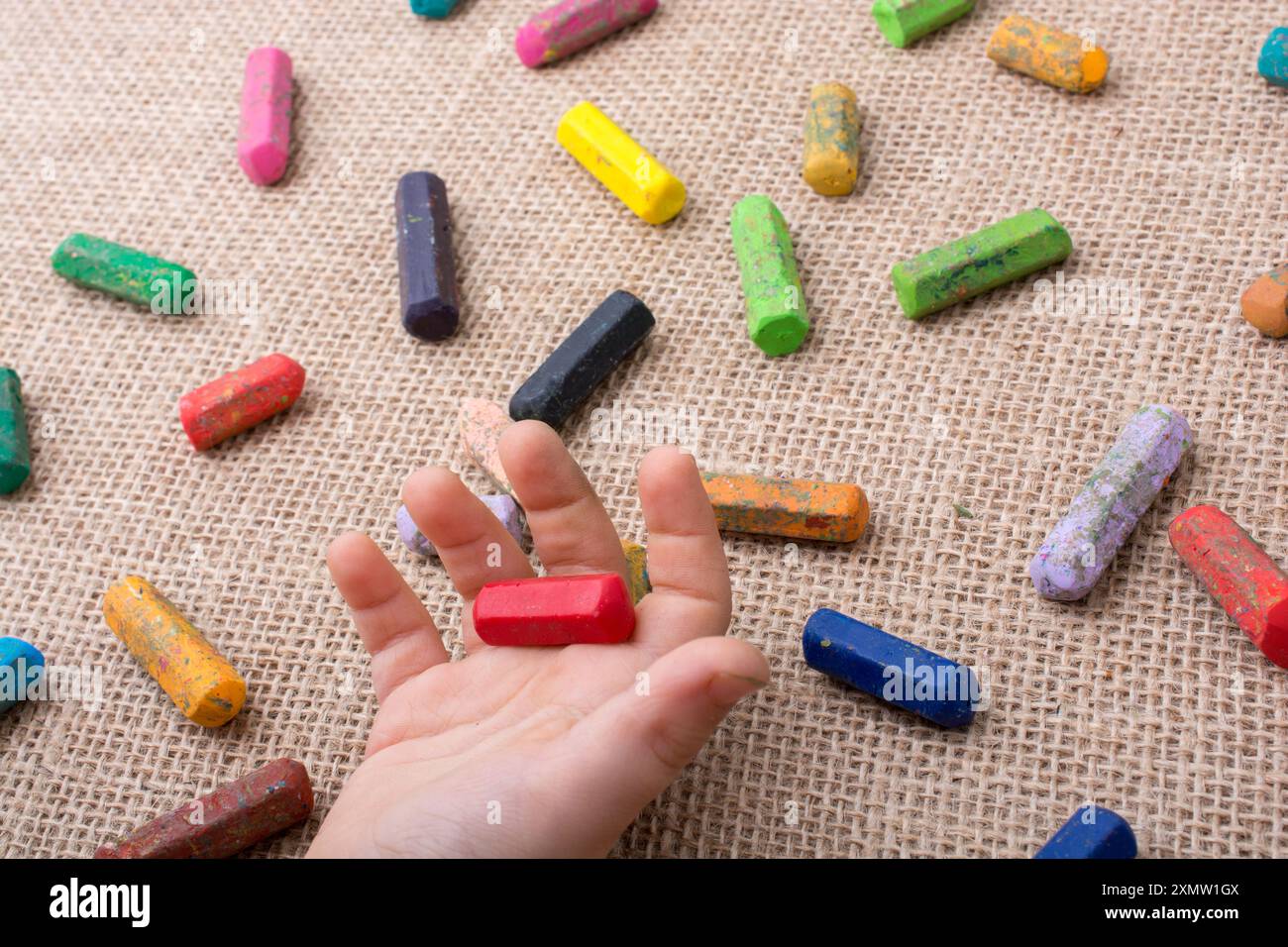 Used color crayons and a toddlers hand holding one Stock Photo - Alamy