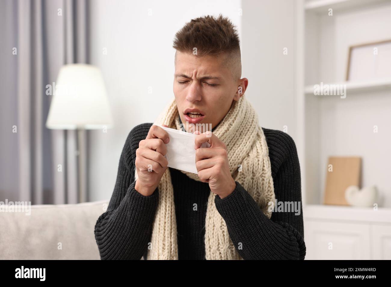 Cold symptom. Young man with runny nose at home Stock Photo - Alamy