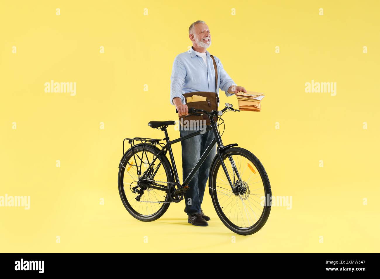 Happy postman with bicycle delivering letters on yellow background ...