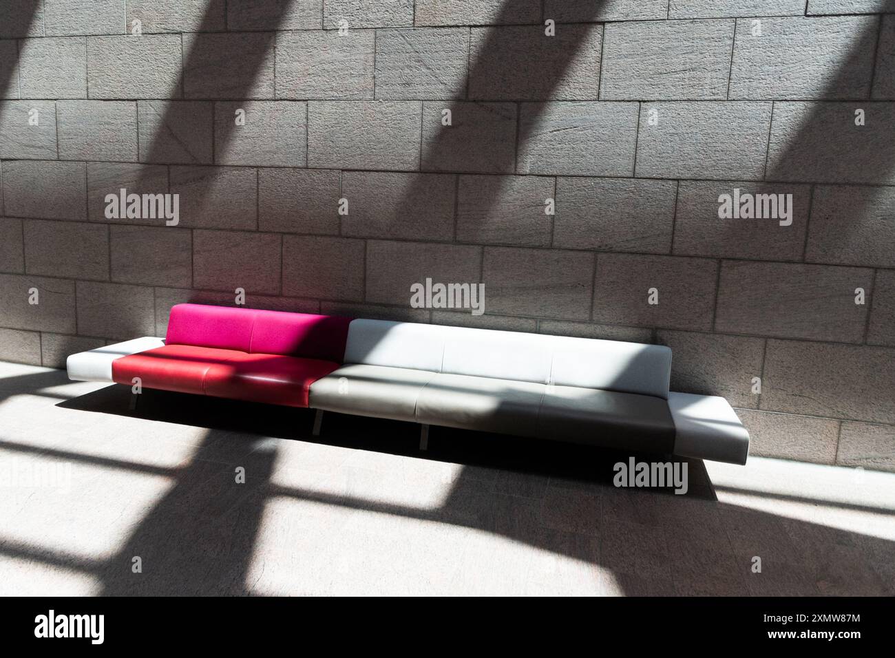 Interior hallway with contemporary, generic seating with concrete wall ...