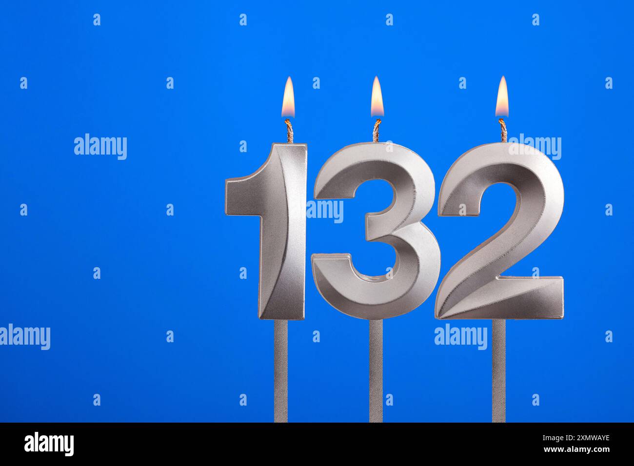 Birthday number 132 - Candle lit on blue background Stock Photo - Alamy