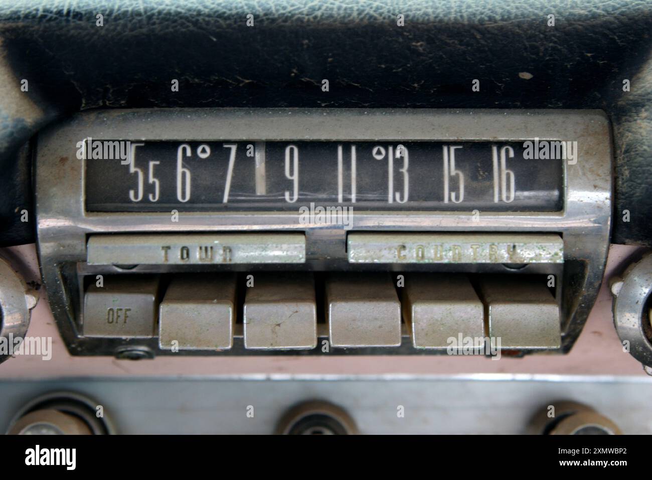 A vintage old AM push button car radio dial in chrome mounted in a ...