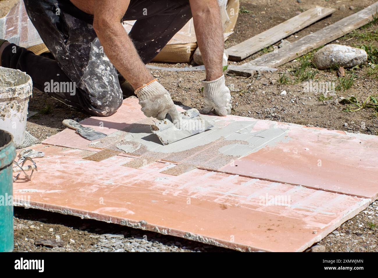 Applying cement-based adhesive mortar to thin flexible panel of fake ...