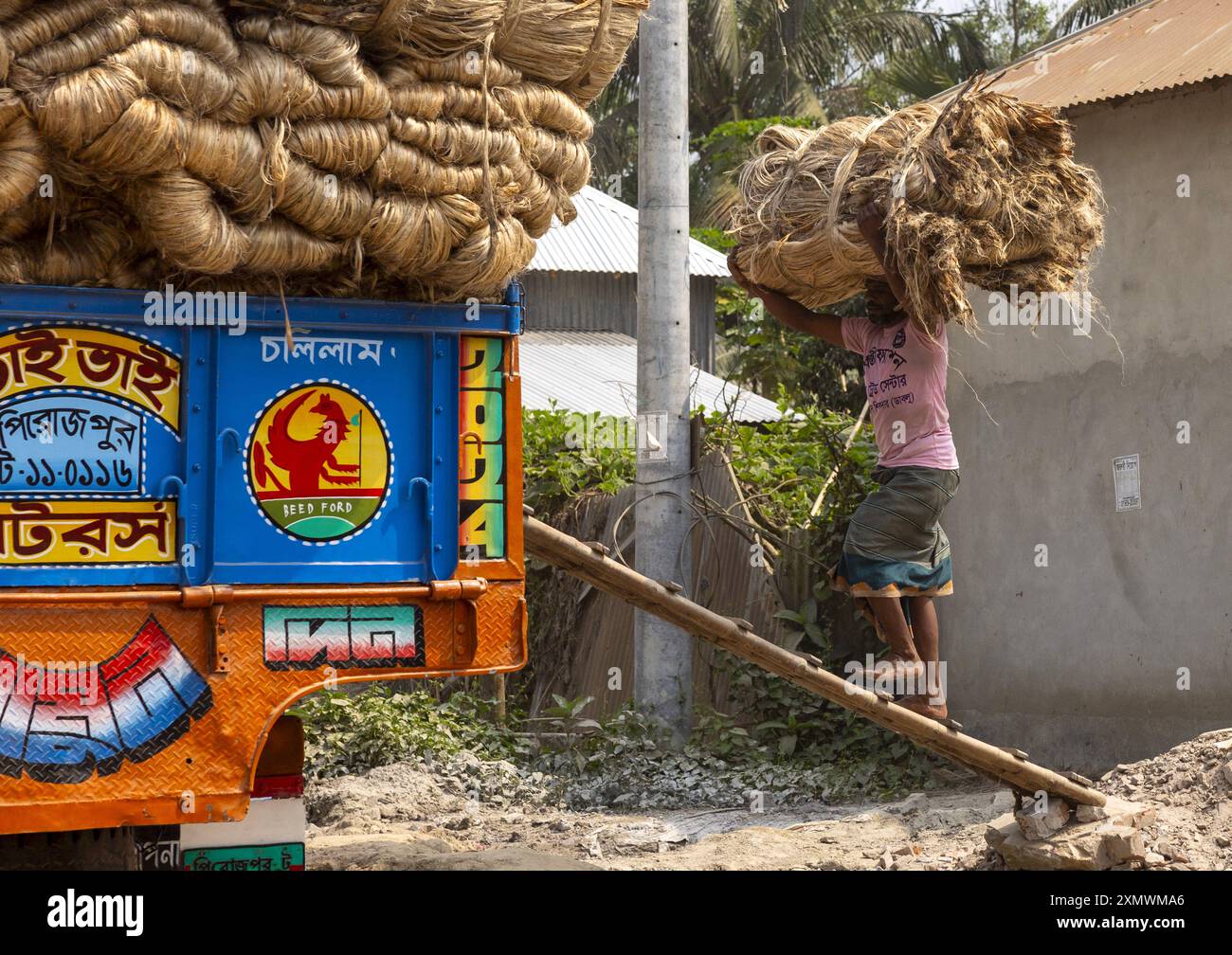 Bangladeshi man loading burlap on a truck, Dhaka Division, Nagarpur ...