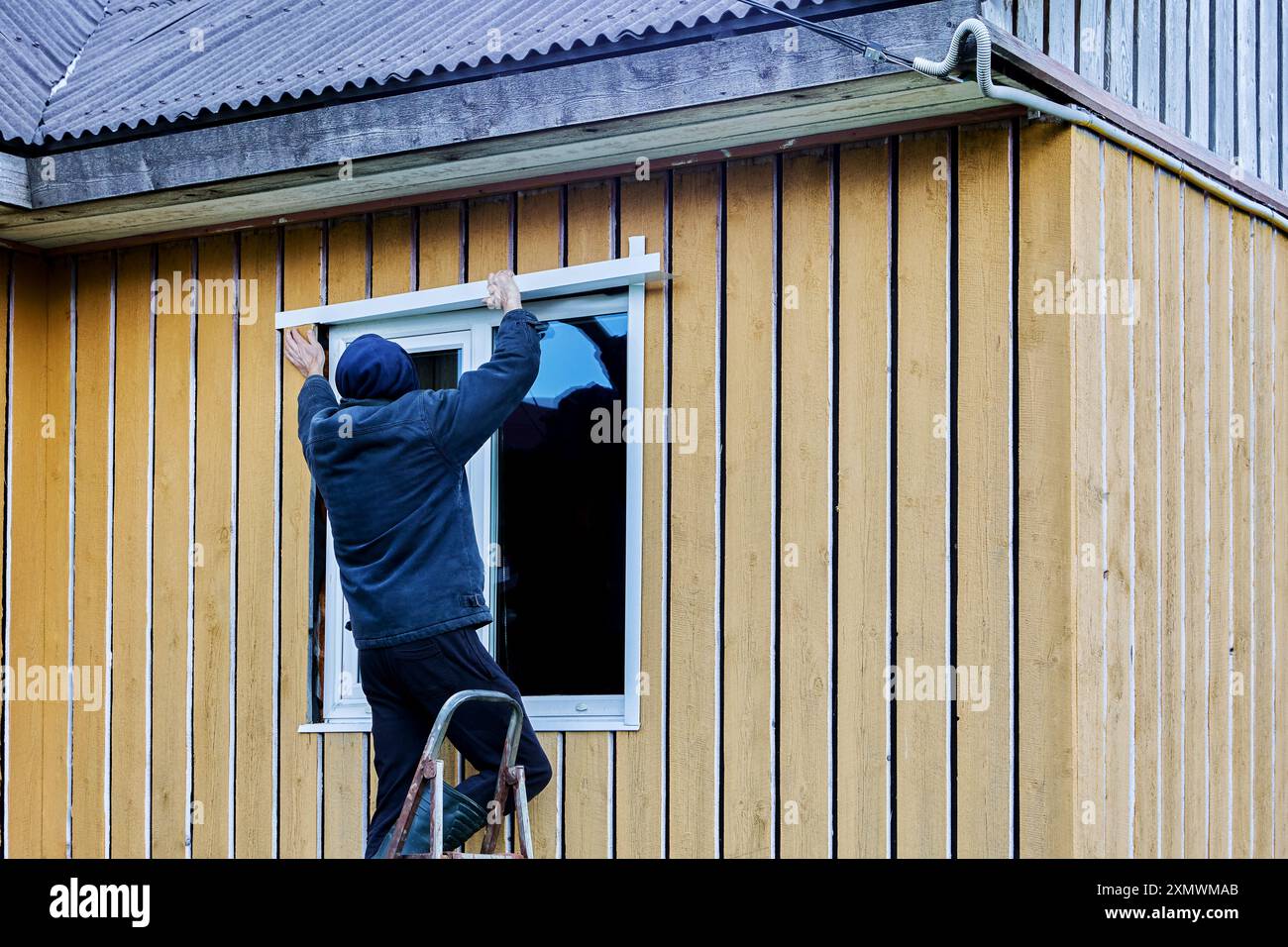 Exterior finishing work on frame and panel house on facade side, roofer ...