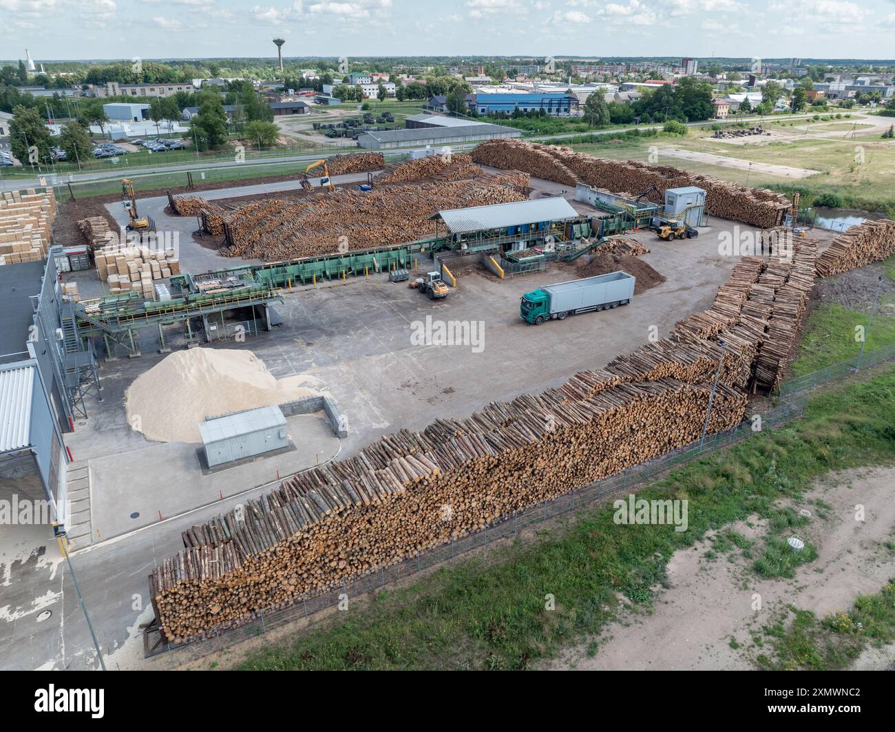 Wood sawmill, machinery for processing wood. Processing plant. A worker ...
