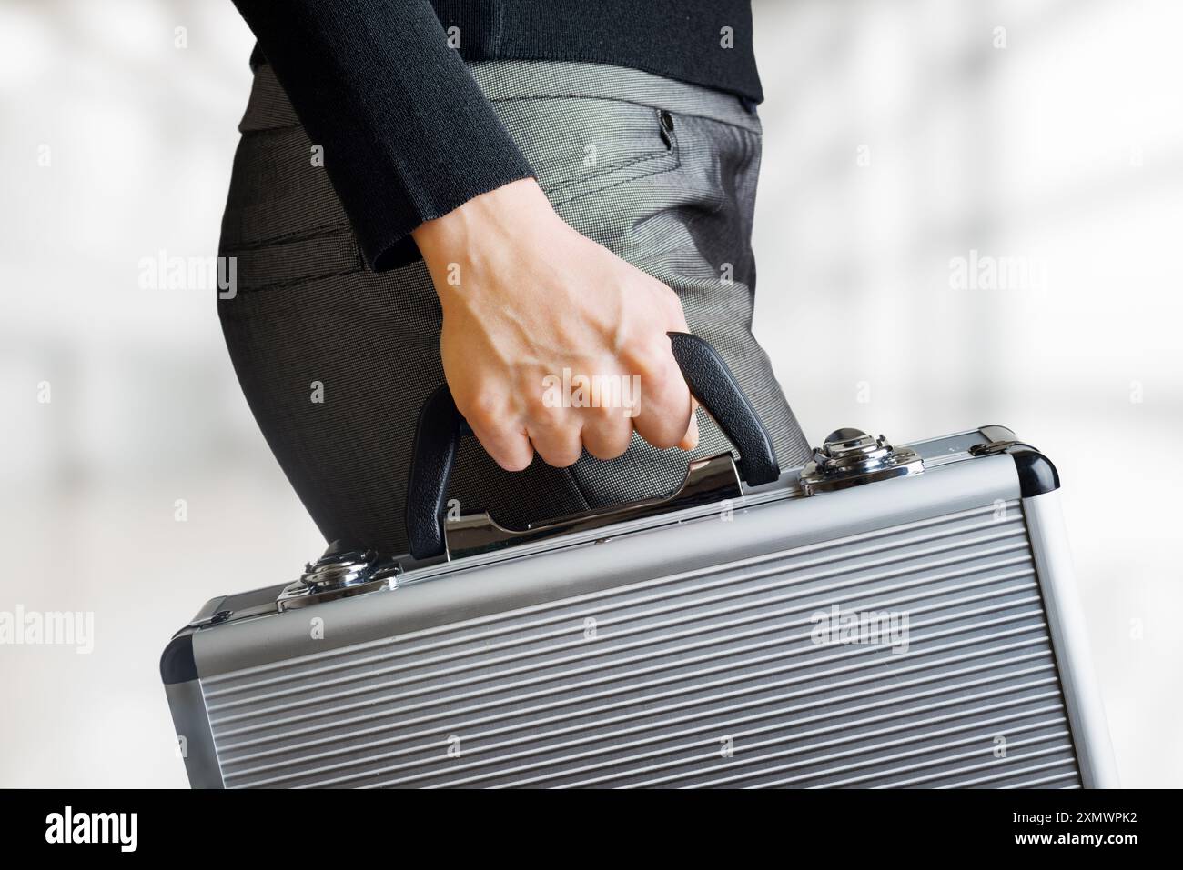 Business woman holding an aluminium briefcase Stock Photo - Alamy