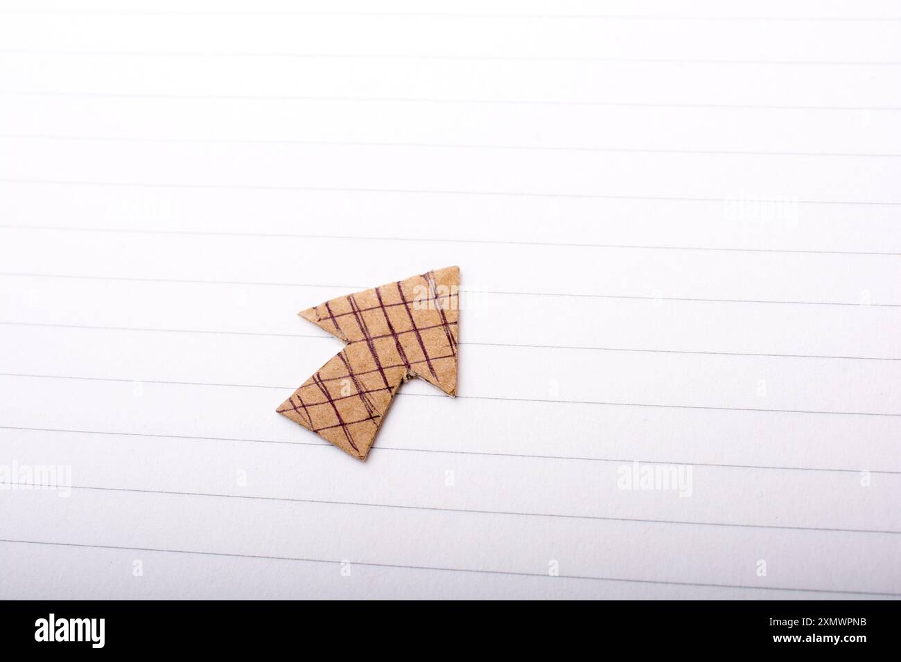 Arrow sign cut out of paper placed on paper on paper Stock Photo - Alamy