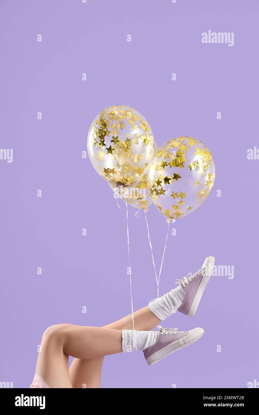 Female legs with balloons on lilac background Stock Photo - Alamy