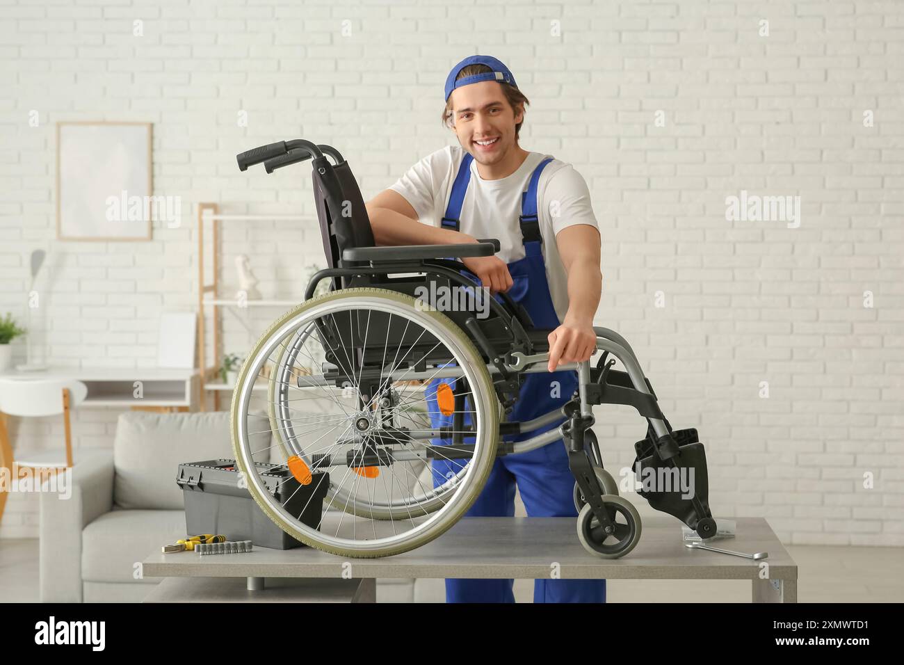 Male worker with wrench repairing wheelchair in room Stock Photo - Alamy
