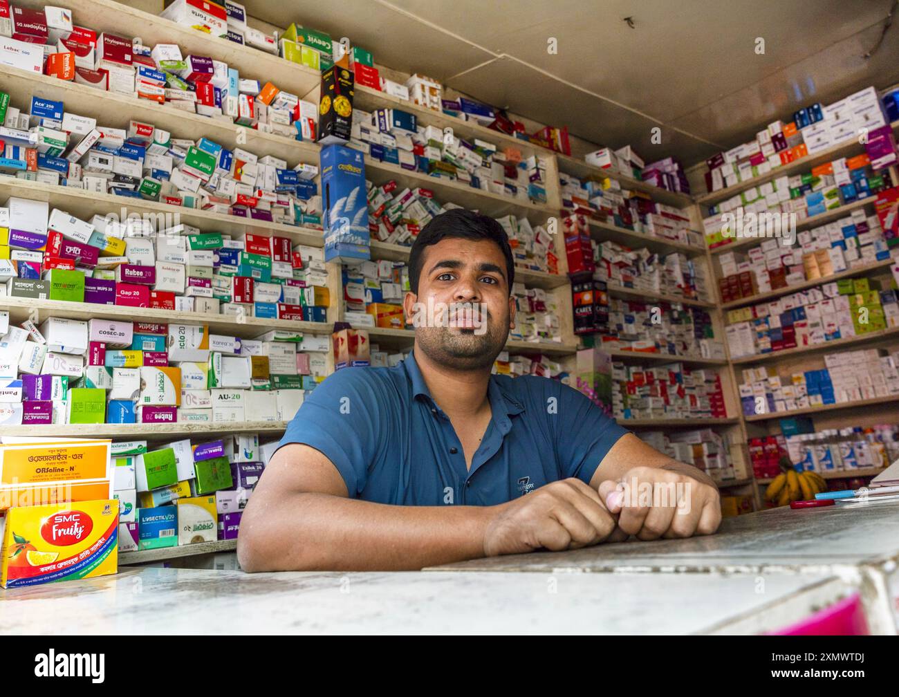 Bangladeshi pharmacist at the desk of his pharmacy, Dhaka Division ...