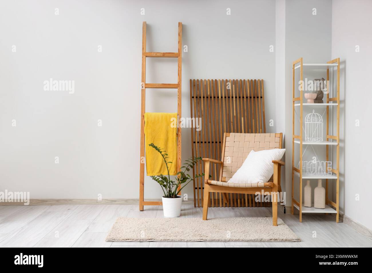 Interior of living room with wooden ladder, armchair and shelf unit ...