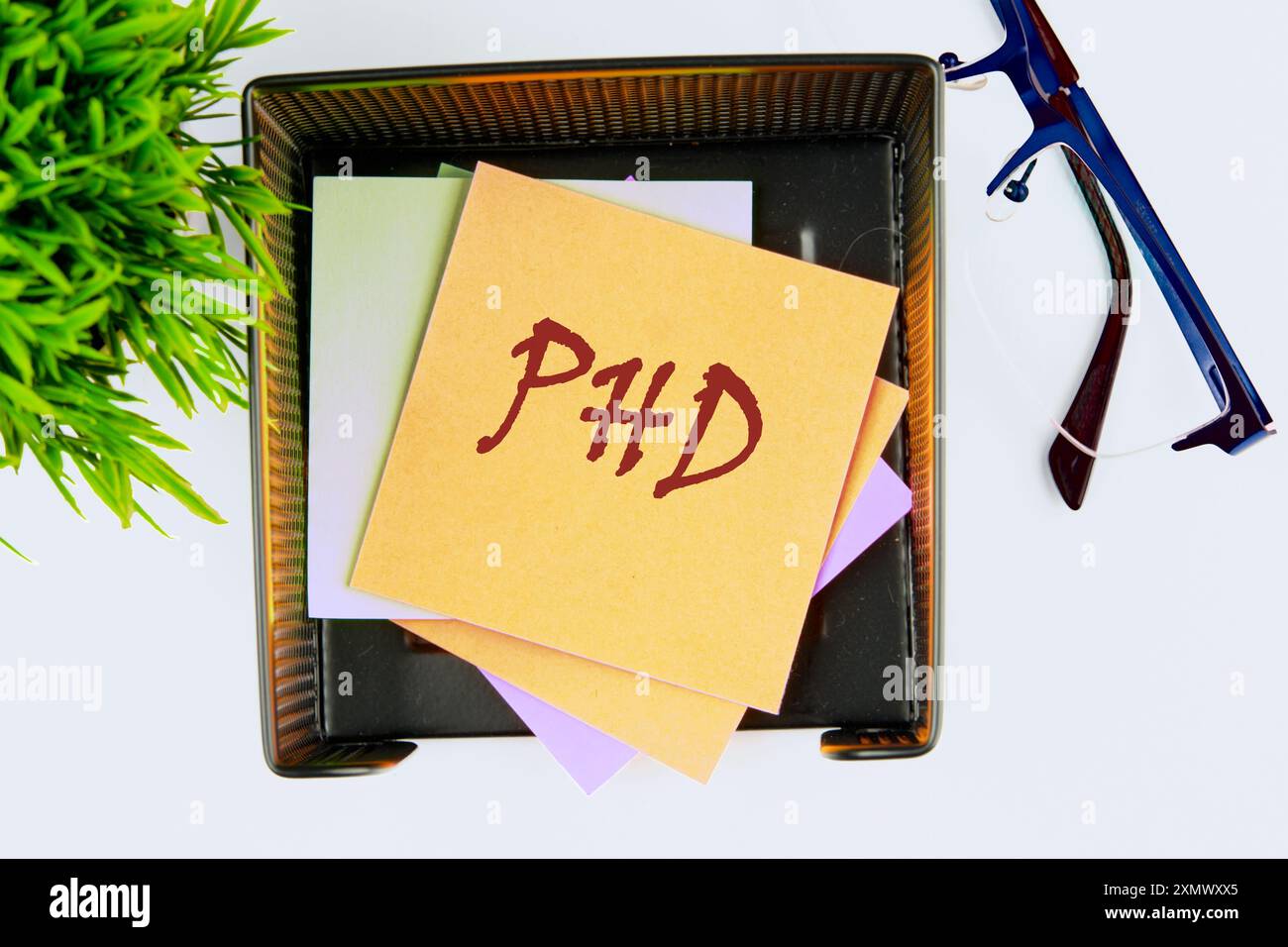 Doctorate of Philosophy concept. PhD on yellow sticker has a top view ...