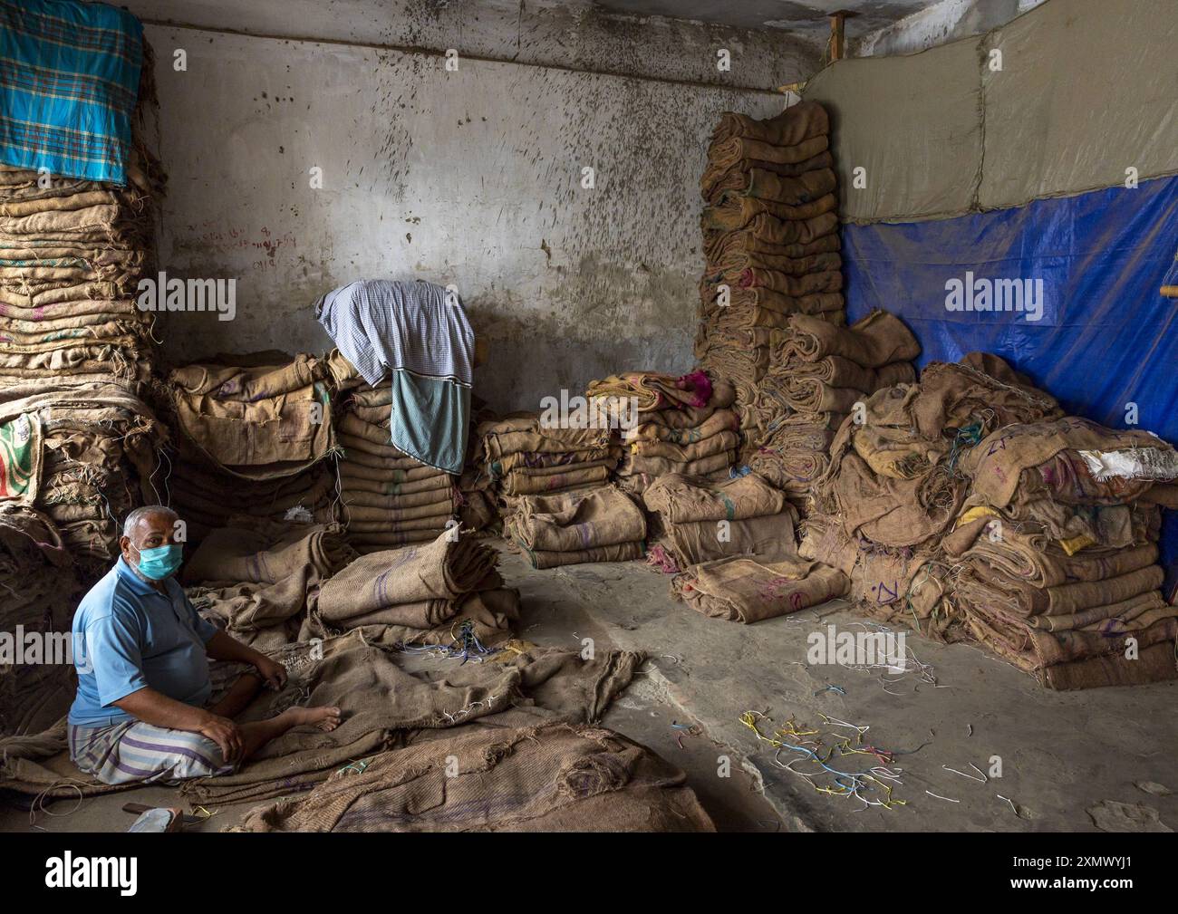 Bangladeshi man packing burlap sacks in Kawran bazar, Dhaka Division ...