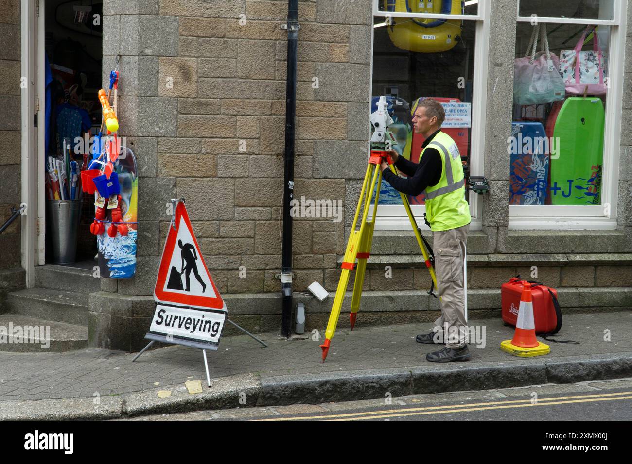 man in st ives street carrying out survey survey sign and high vis ...