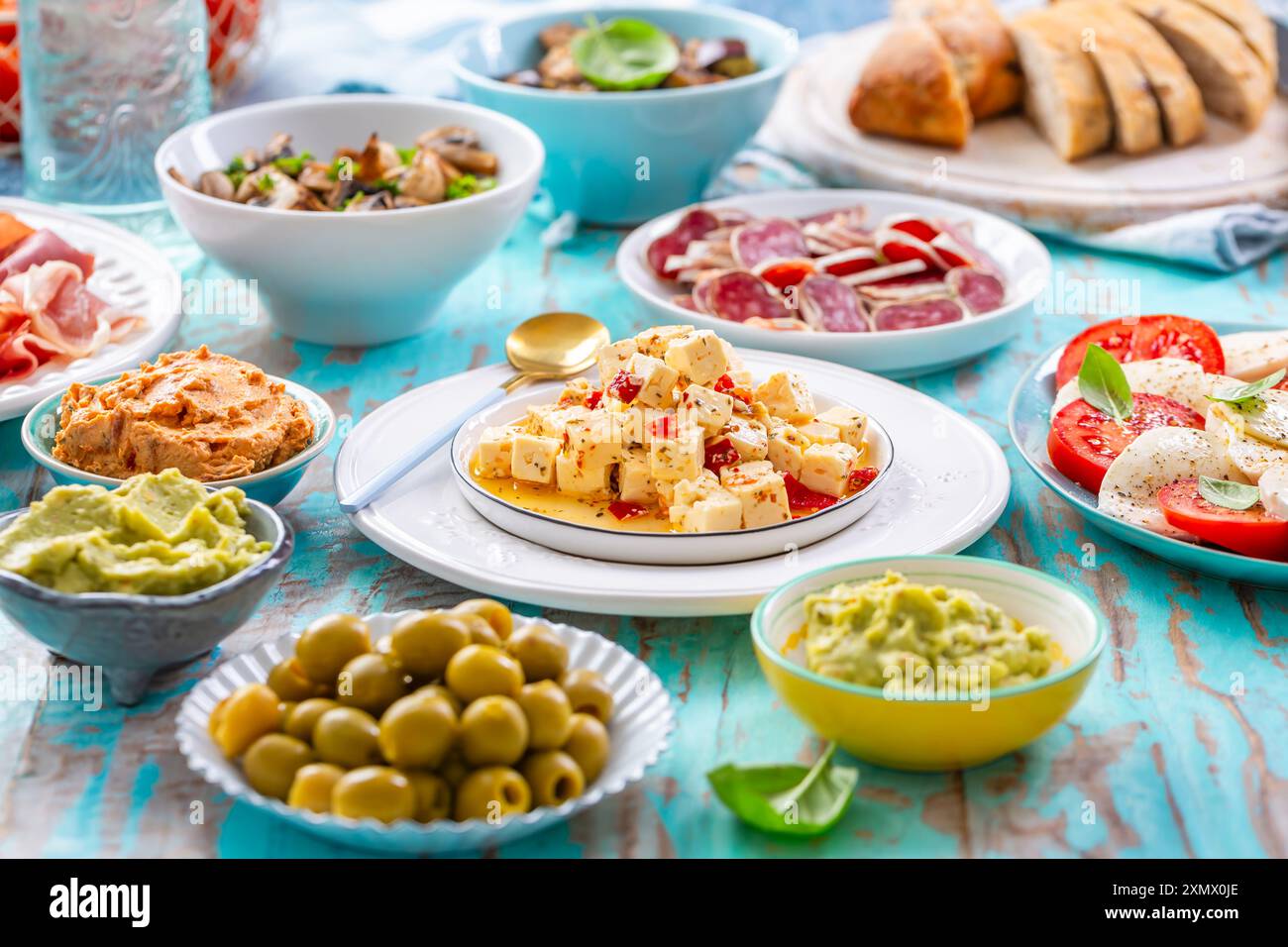 Picnic table with assorted appetizers, raw vegetables, cheese, dips ...