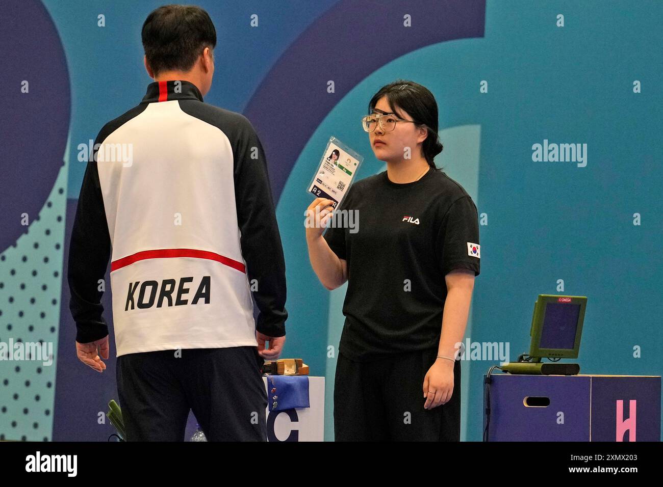 South Korea's Oh Ye-Jin, right, fans herself with her identity card as ...