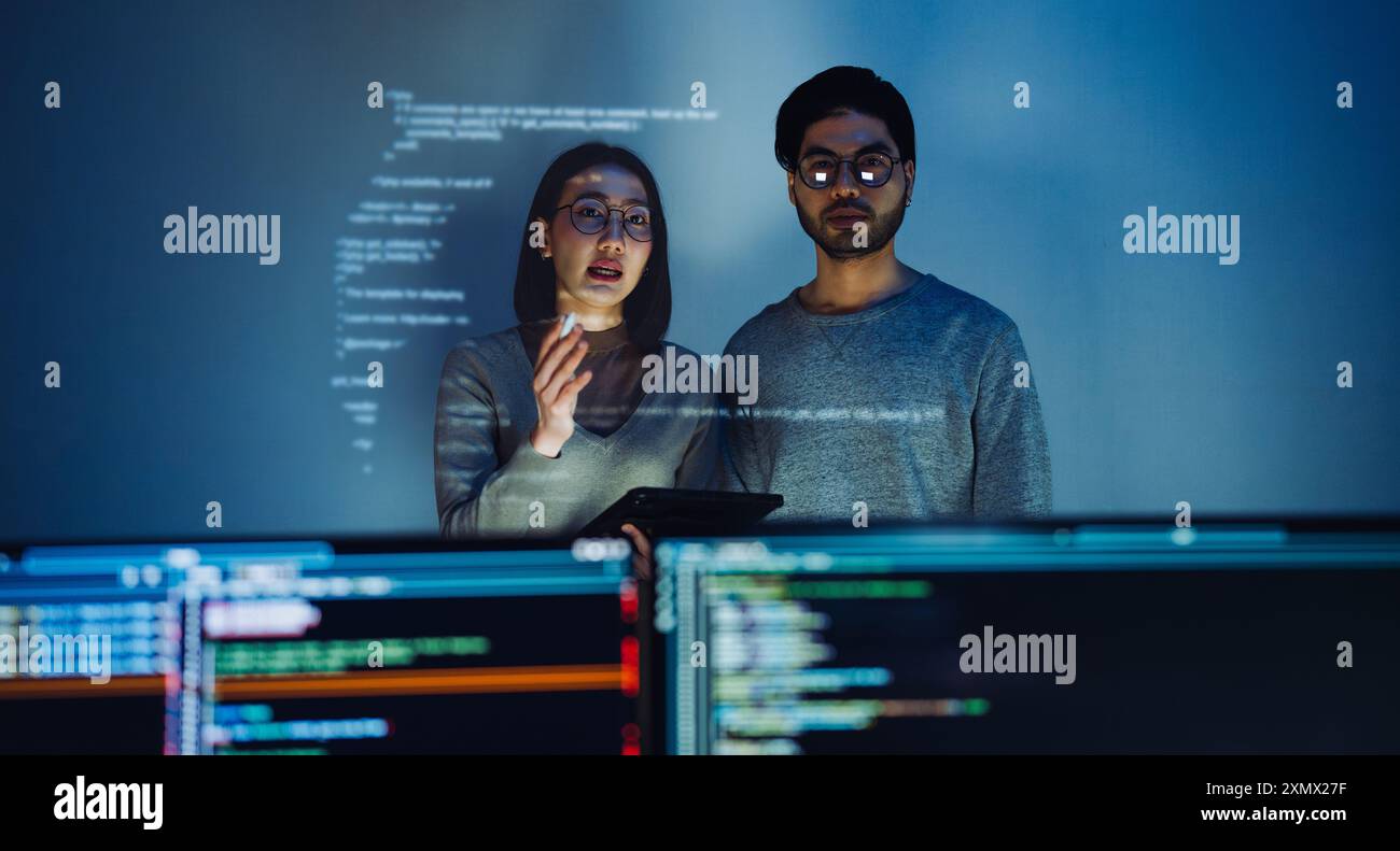 Asian Two software developers engaged in collaborative coding session ...