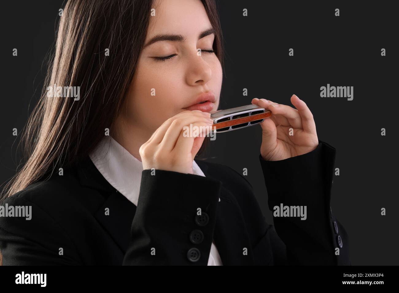 Female artist playing harmonica on dark background, closeup Stock Photo ...