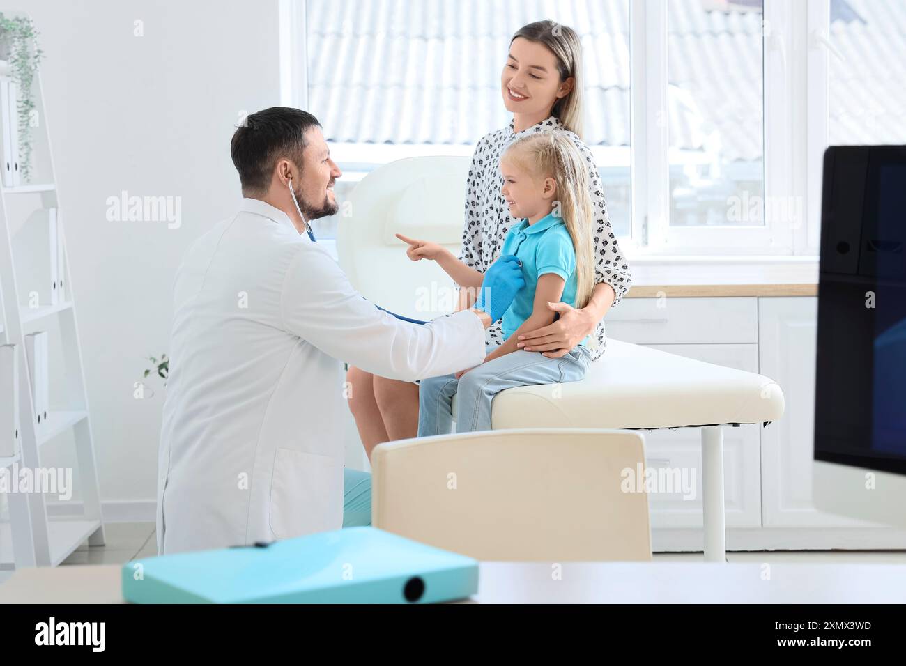 Male endocrinologist with stethoscope listening to little girl and her ...