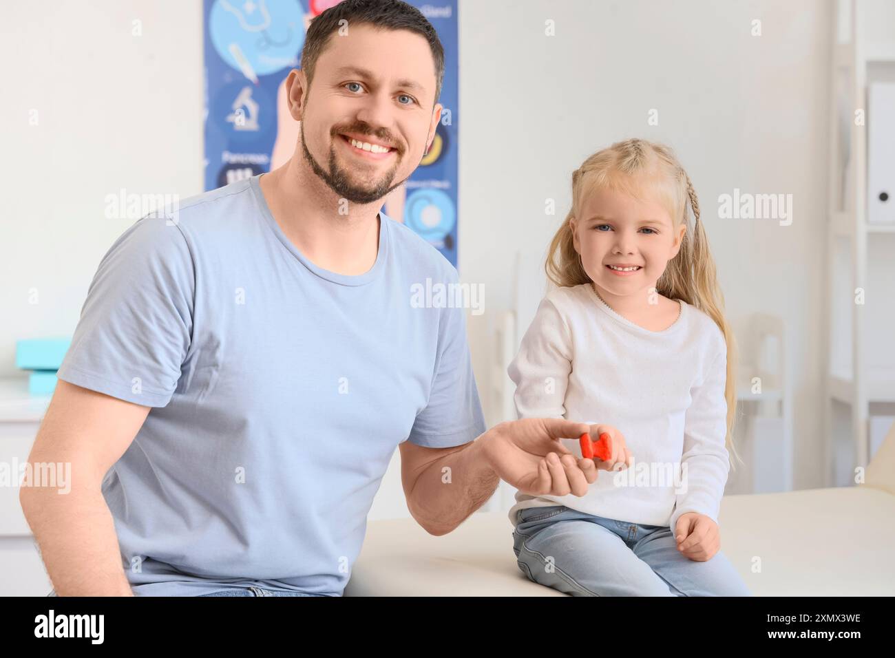 Little girl with thyroid gland model and her father sitting on couch at ...